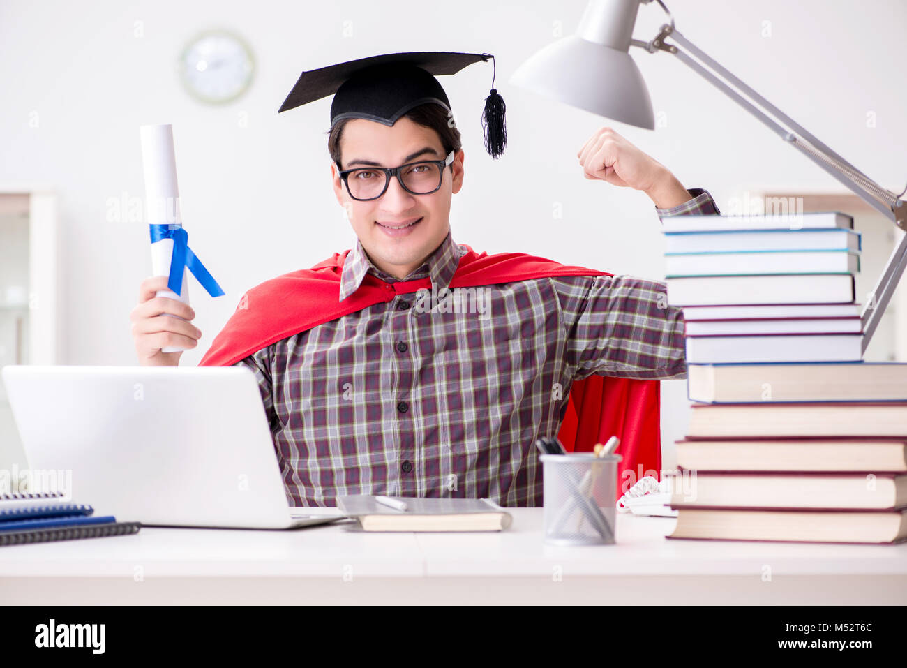 Super hero student wearing a mortarboard studying Stock Photo - Alamy