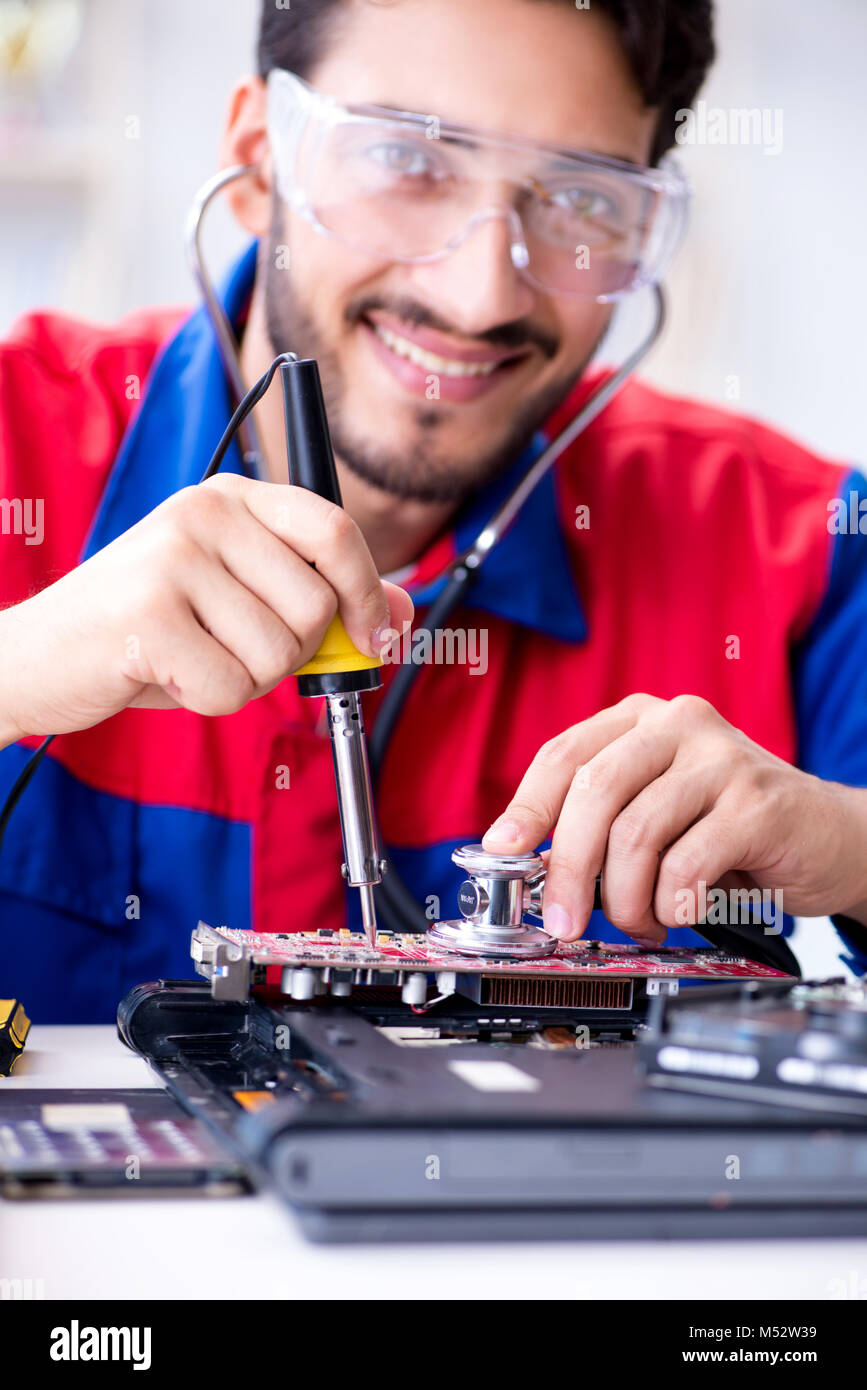 Repairman working in technical support fixing computer laptop tr Stock Photo - Alamy