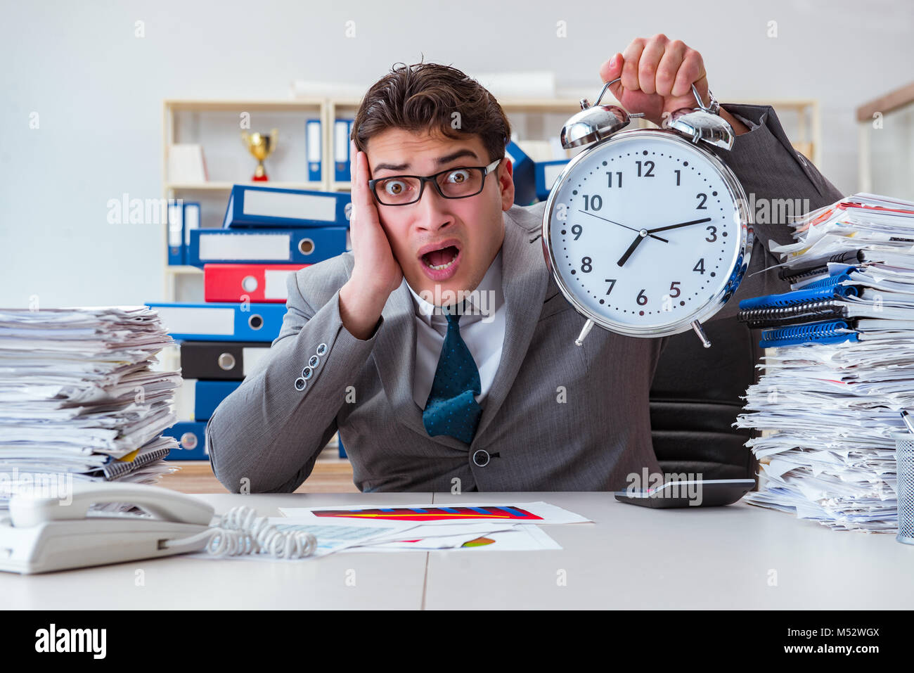 Businessman missing deadlines due to excessive work Stock Photo - Alamy