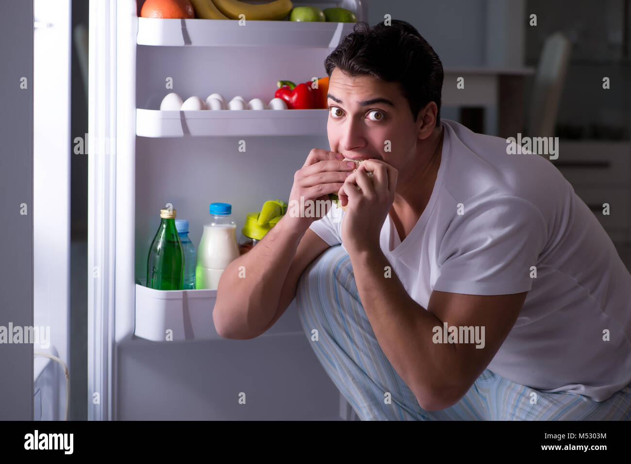Man opening refrigerator at night hi-res stock photography and images ...