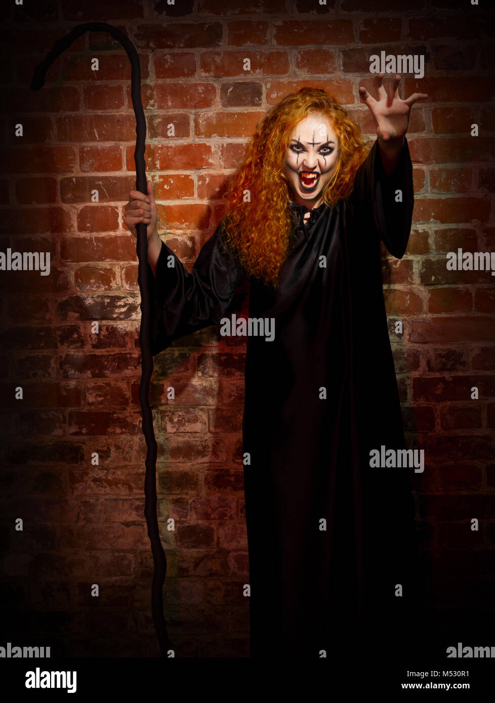 Scary witch at brick wall background Stock Photo - Alamy