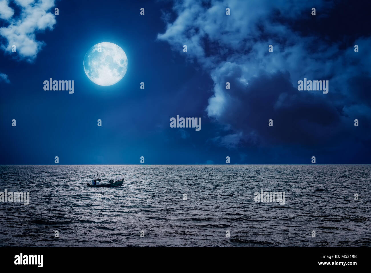 Small fisherman boat sailing on a full moon night Stock Photo - Alamy