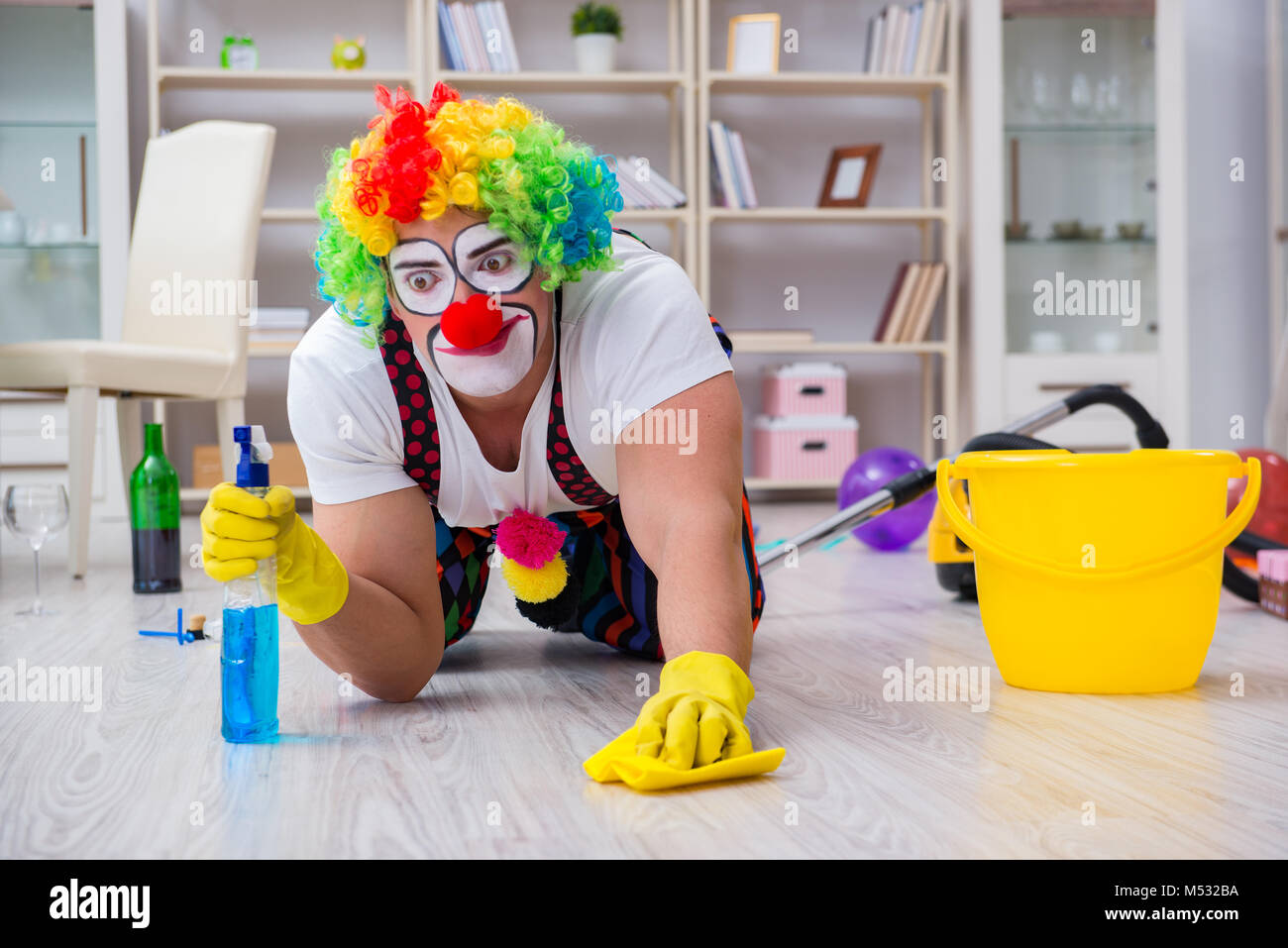 Funny clown doing cleaning at home Stock Photo - Alamy