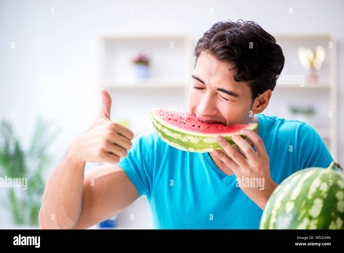 Man eating watermelon at home Stock Photo - Alamy