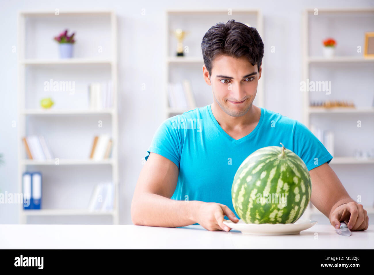 Man eating watermelon at home Stock Photo - Alamy