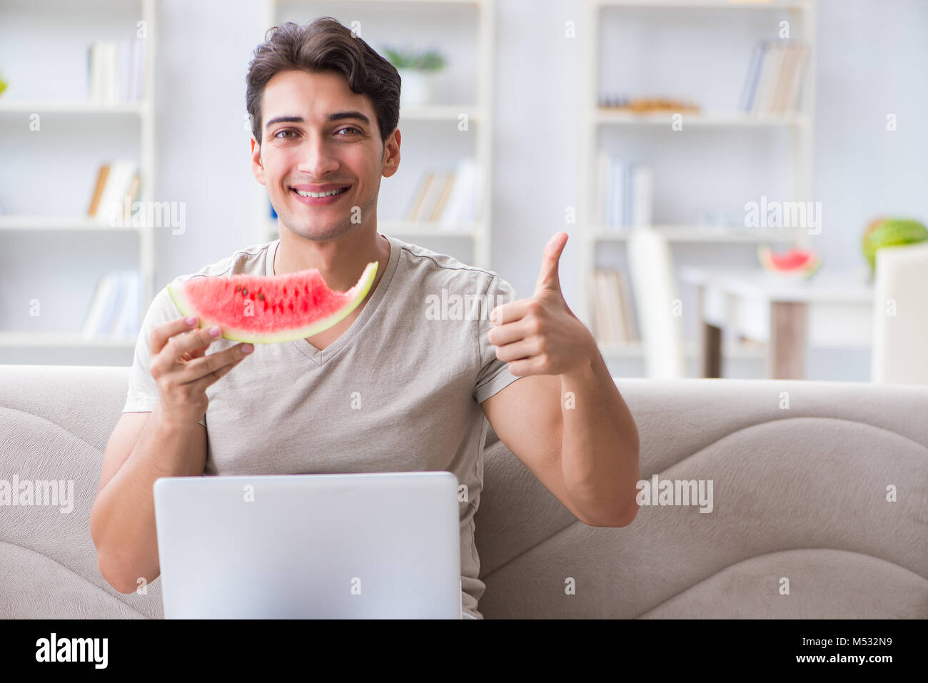 Man eating watermelon at home Stock Photo - Alamy