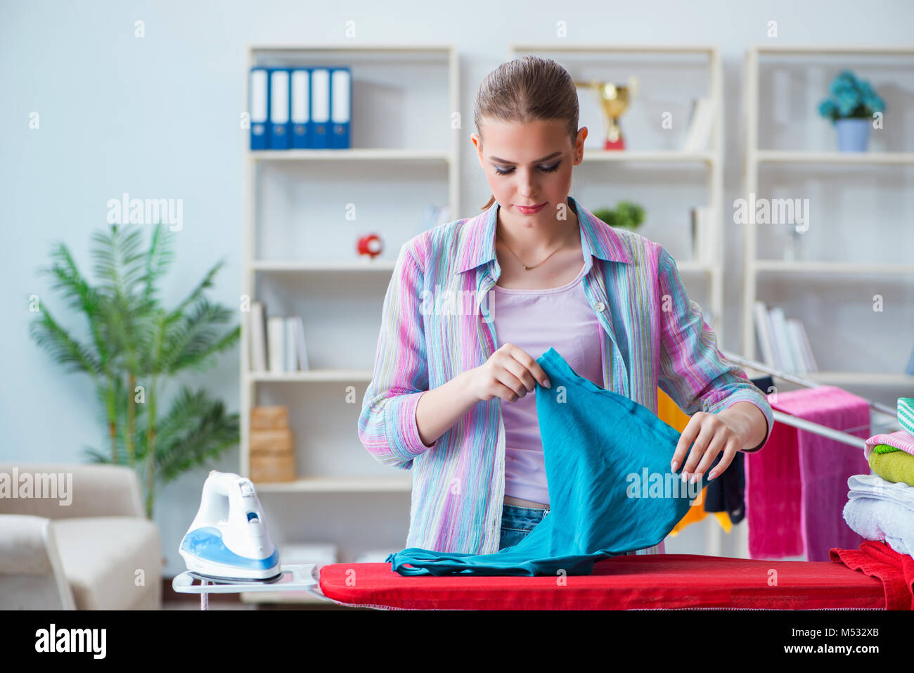 Happy housewife doing ironing at home Stock Photo - Alamy