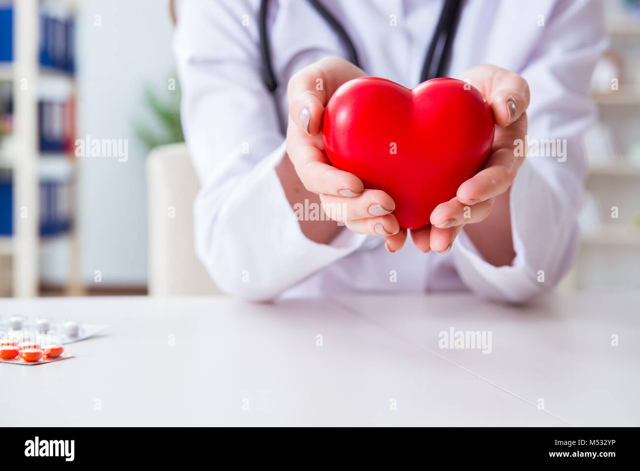 Doctor cardiologist with red heart in the hospital Stock Photo - Alamy