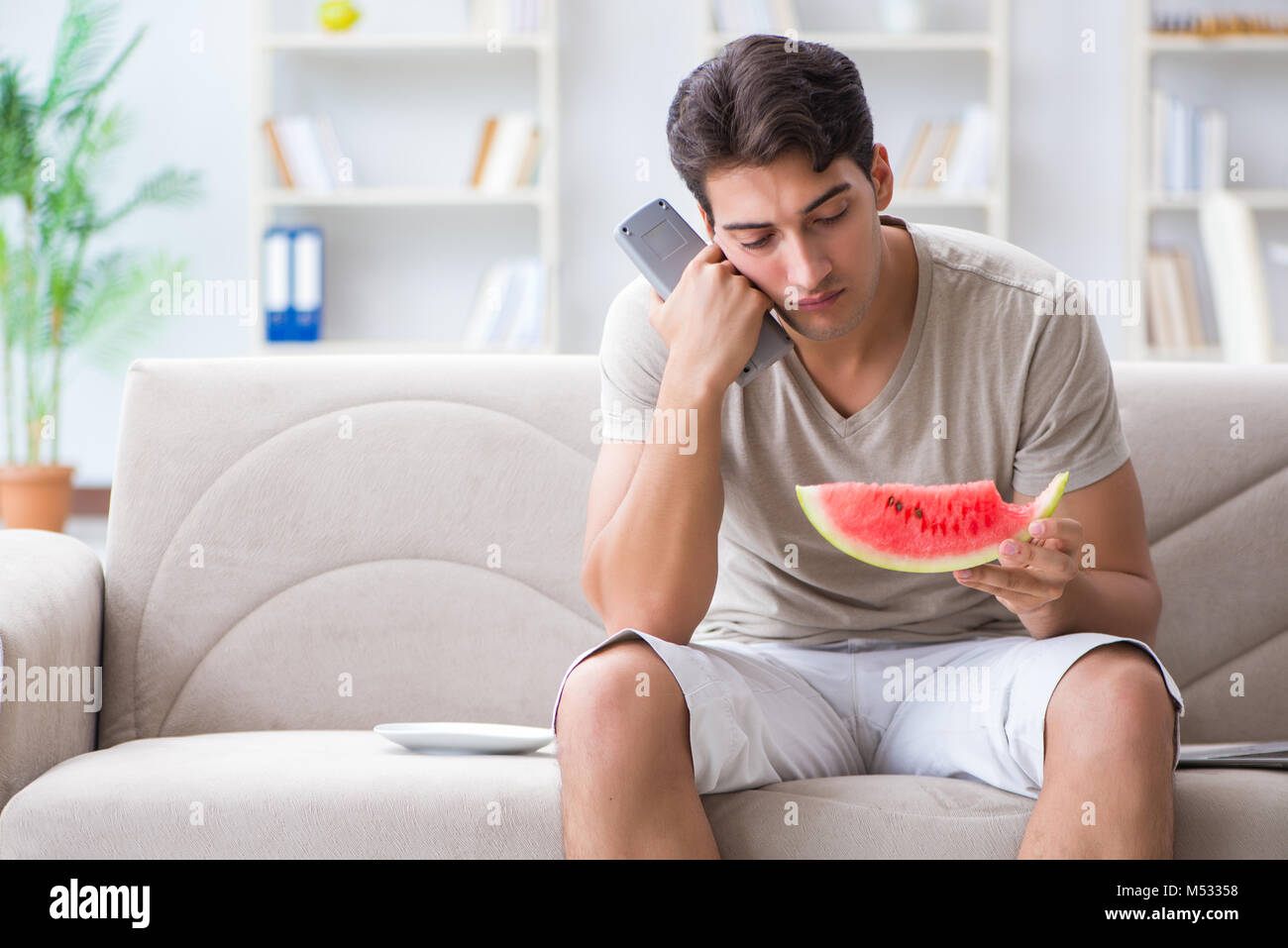 Man eating watermelon at home Stock Photo - Alamy