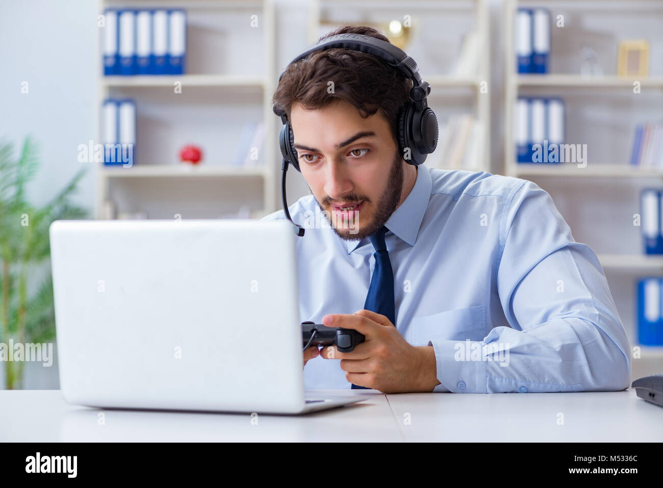 Businessman gamer in office playing games Stock Photo - Alamy
