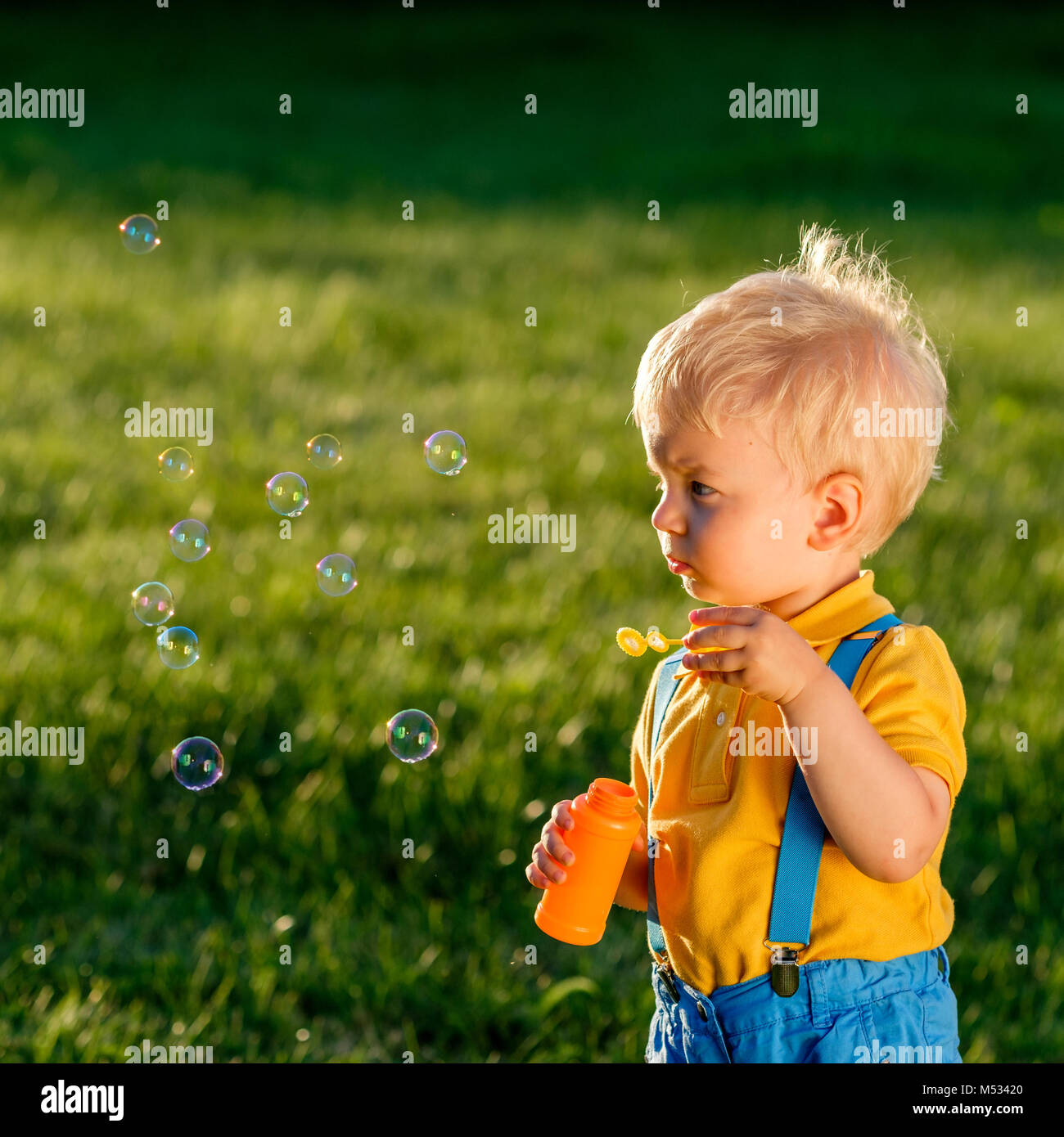 One year old baby boy blowing soap bubbles Stock Photo - Alamy