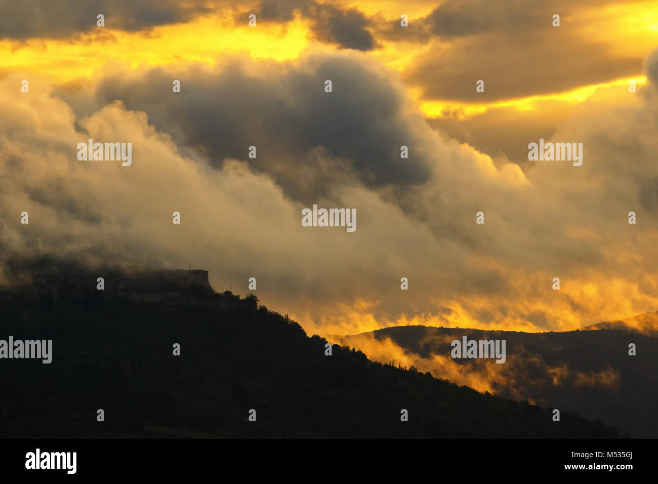 Heavy clouds in dusk sunset with mountains in silhouette Stock Photo ...