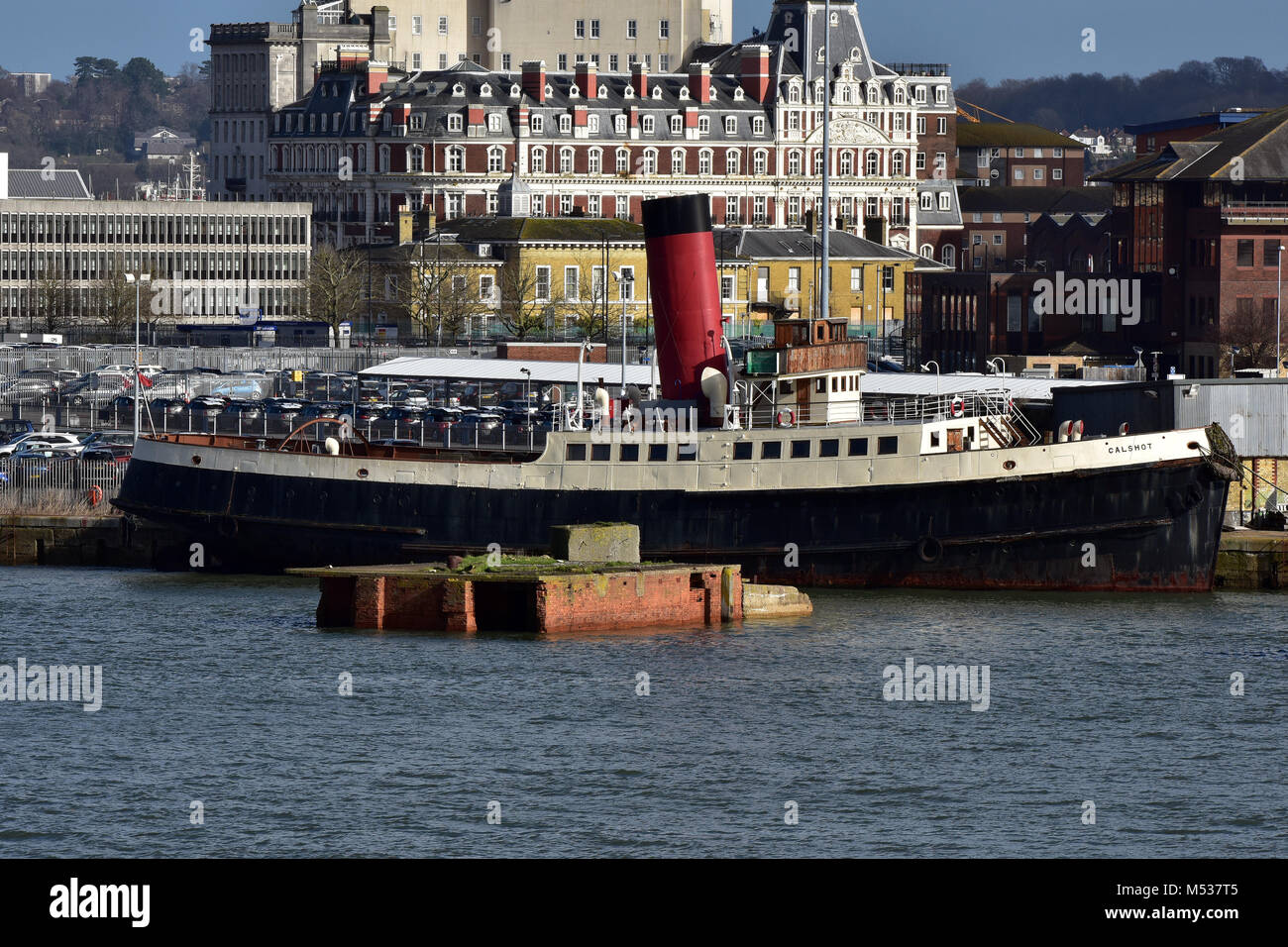 an old fashioned steam tug alongside the harbour wall in the port of ...