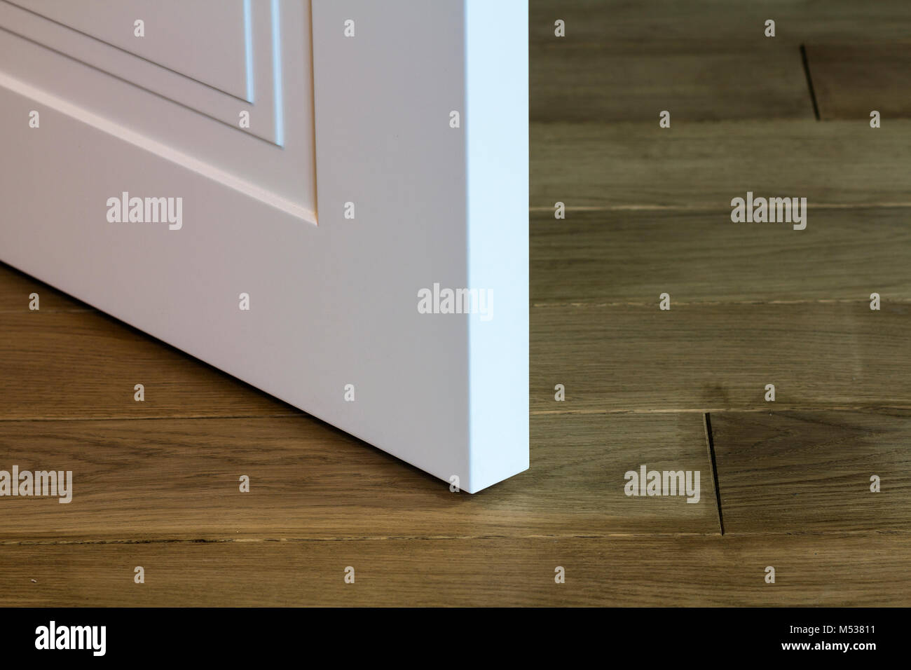 Close-up detail image of modern white door and wooden parquet floor ...