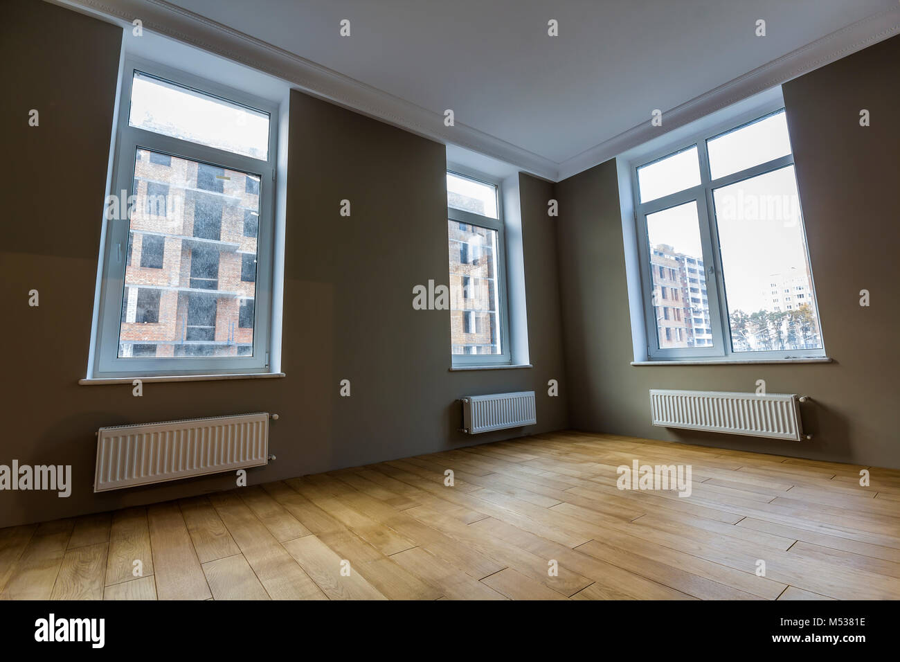 New renovated room interior with big windows, heating radiators and ...