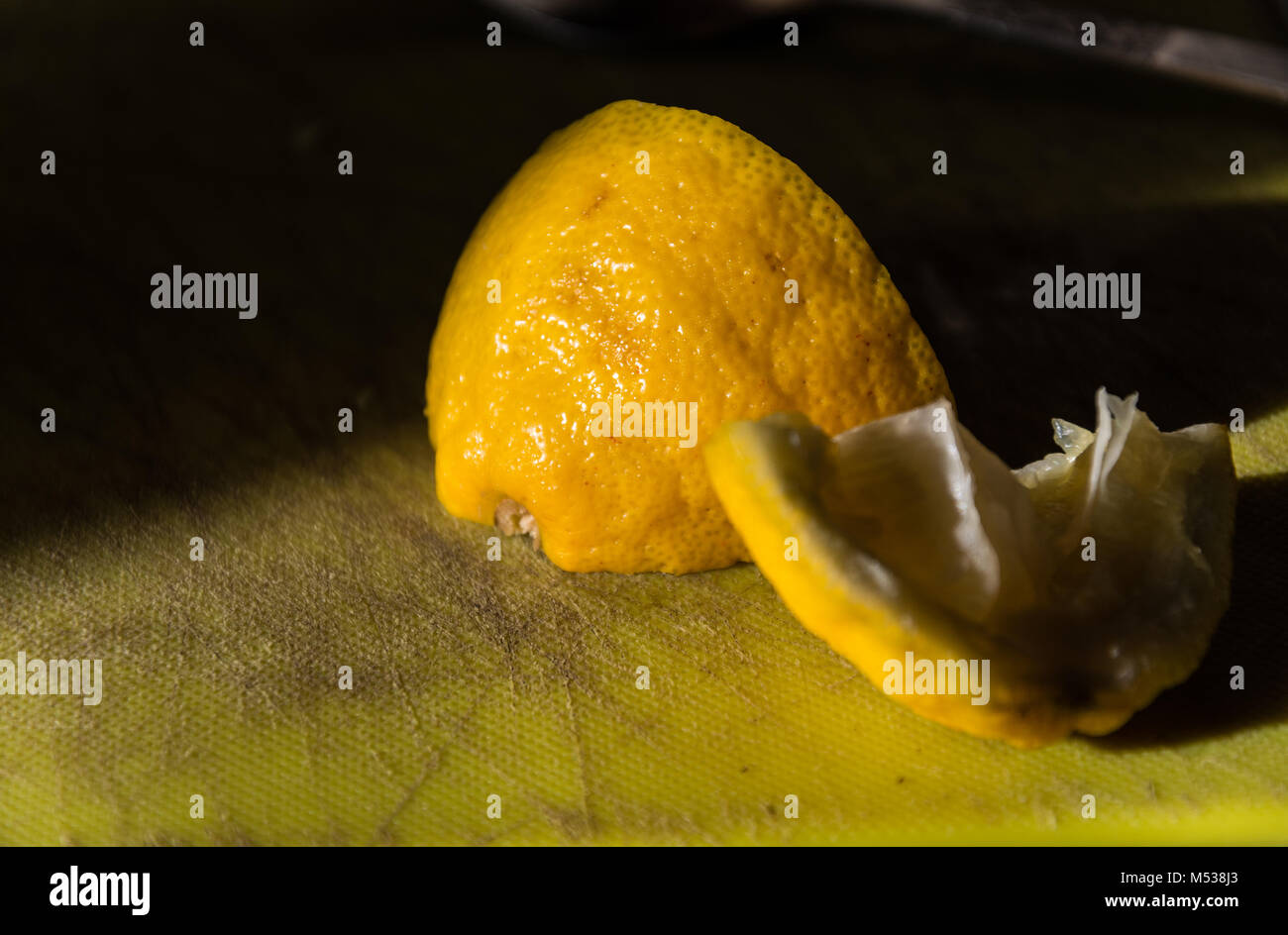 Low-key image of a squeezed lemon on a chopping board Stock Photo - Alamy