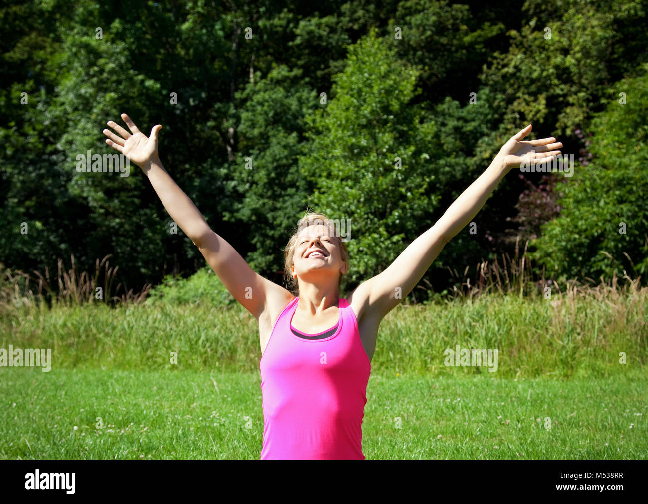 beautiful young woman with raised arms Stock Photo - Alamy