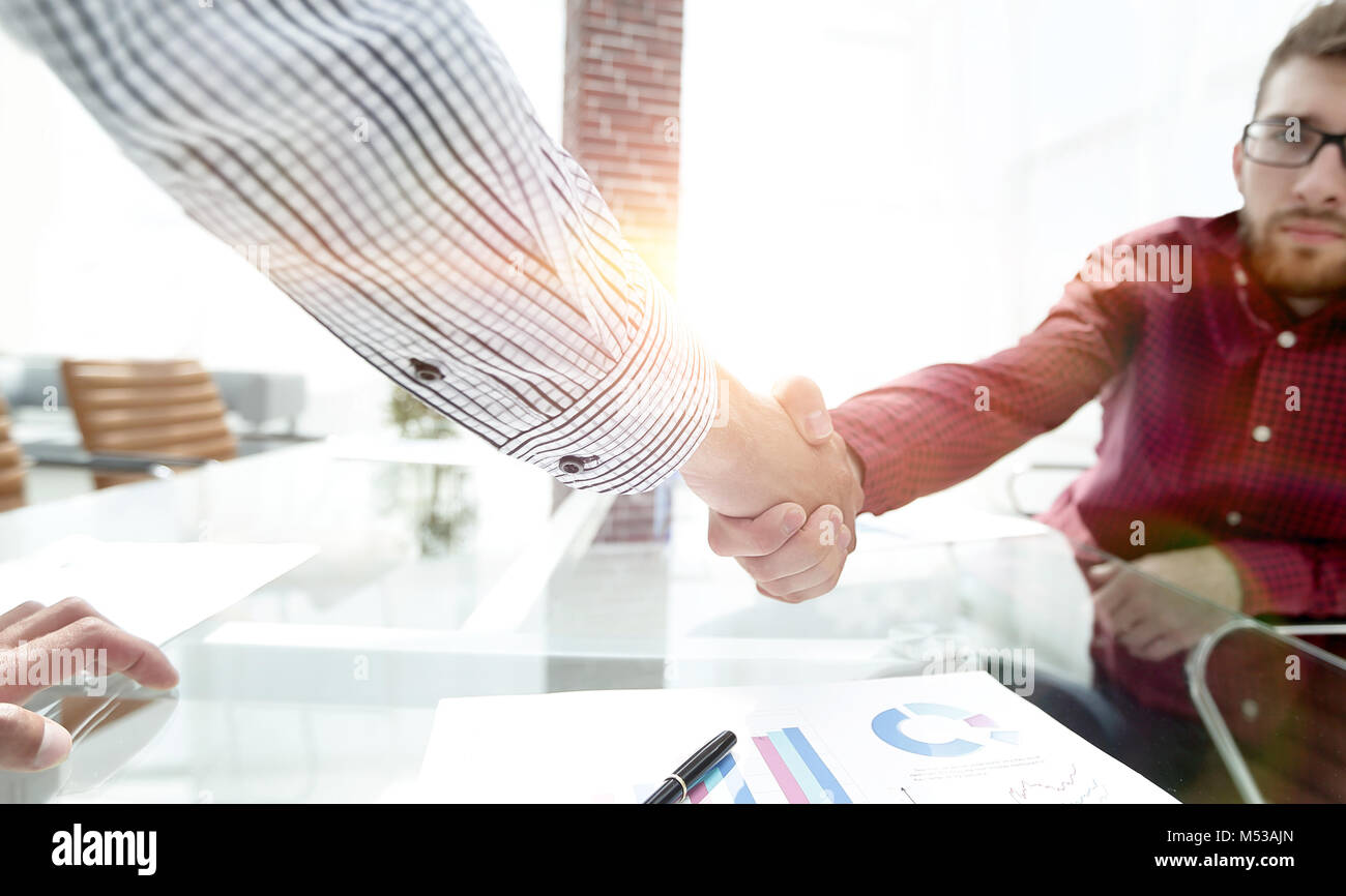 colleagues shaking hands over Desk Stock Photo - Alamy