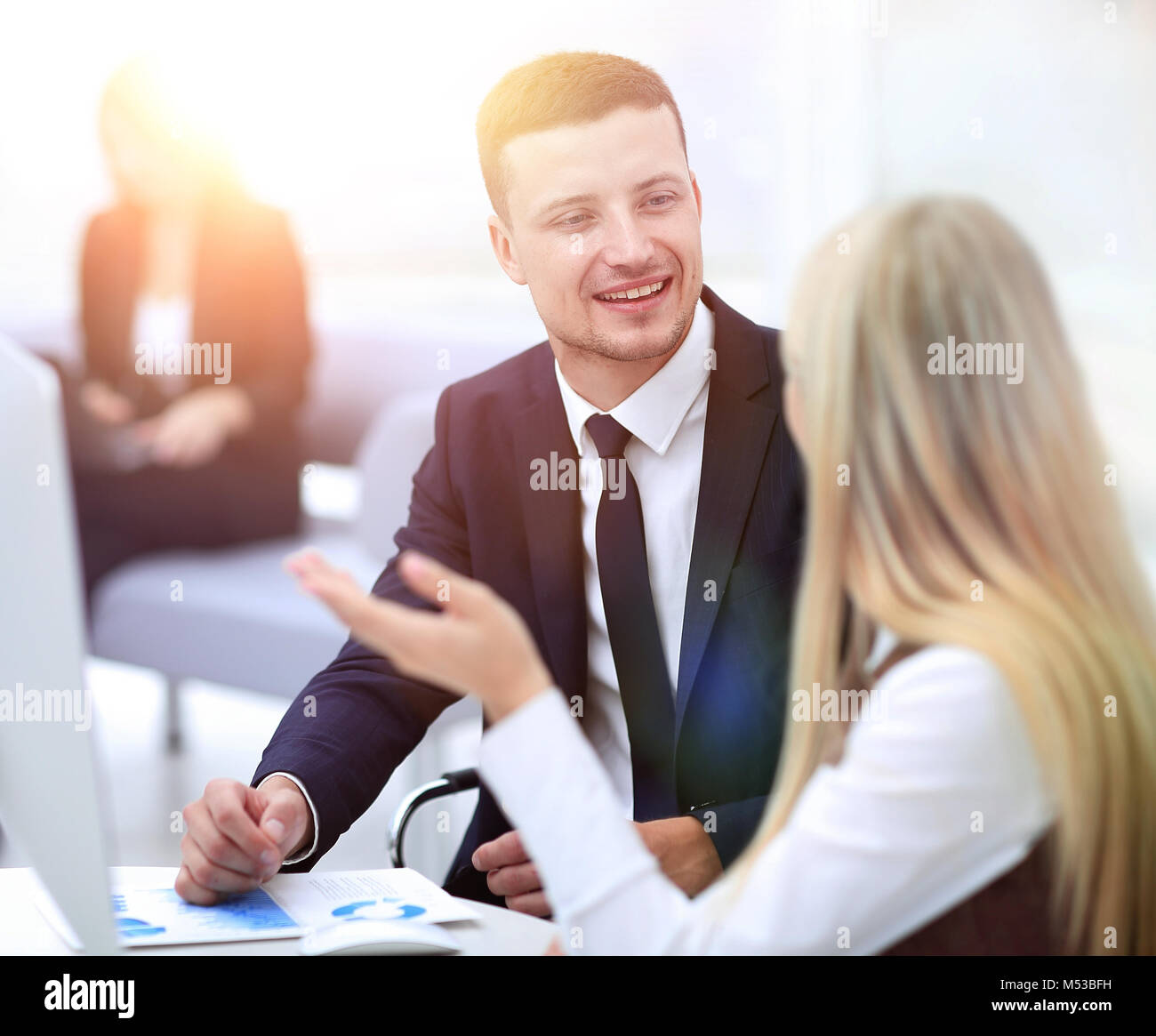 Manager talking with a colleague at the workplace Stock Photo - Alamy