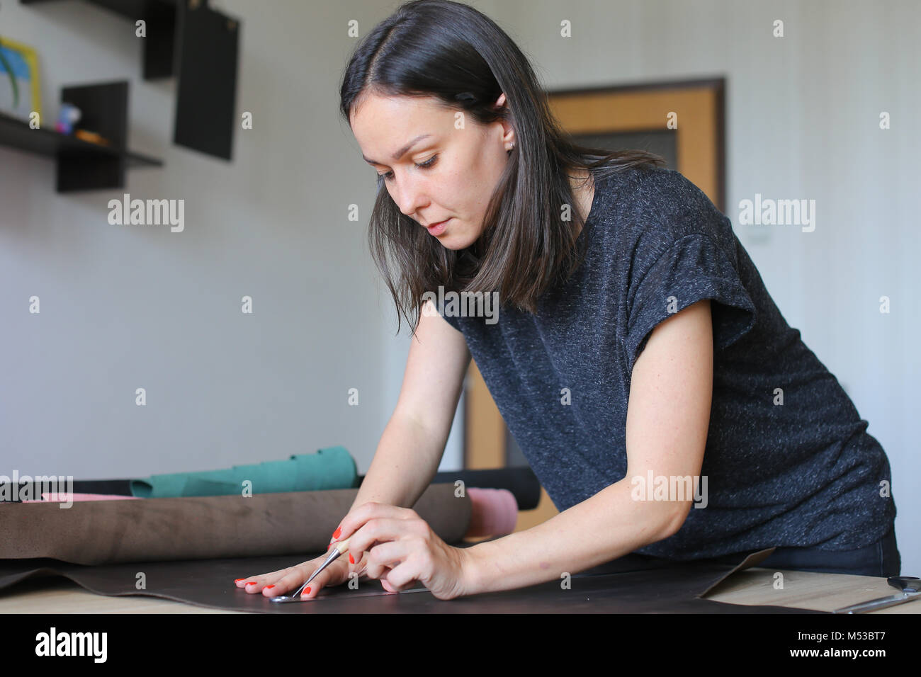 teacher demonstrating students how to work with leather Stock Photo - Alamy