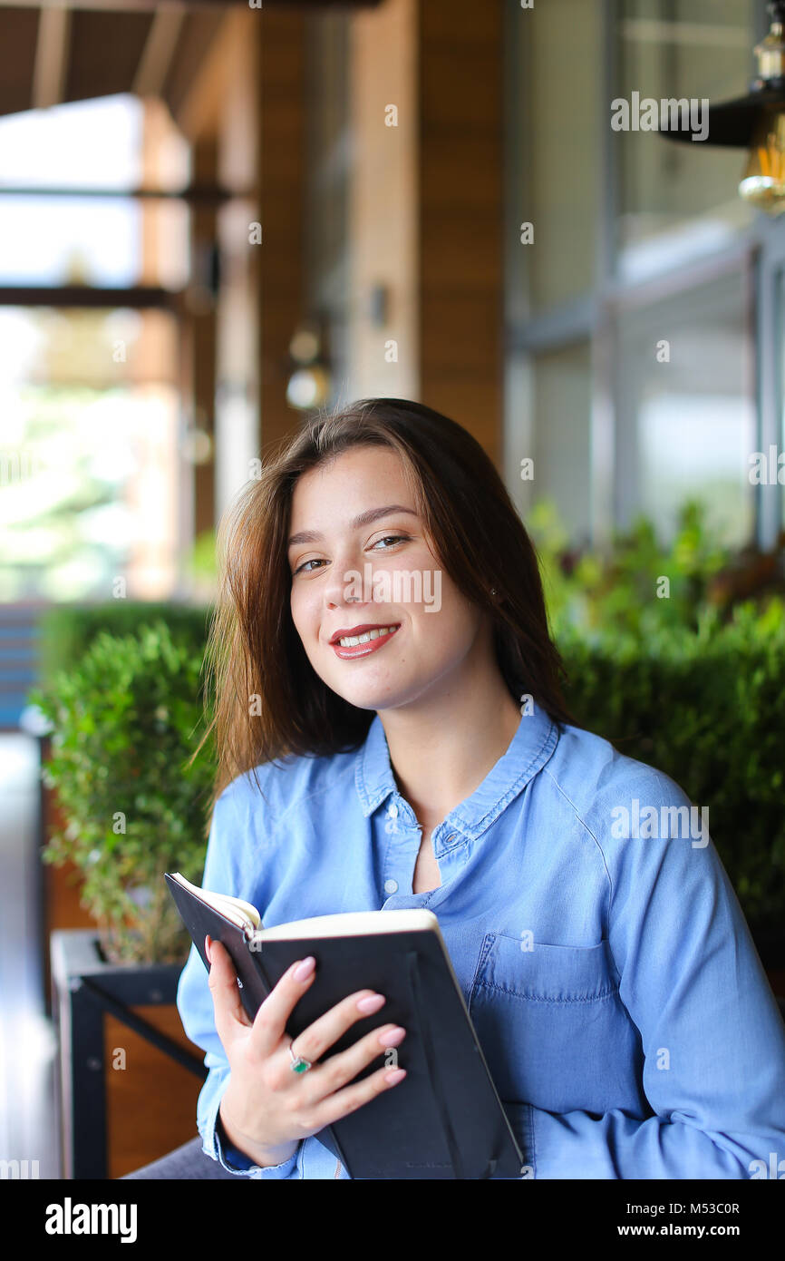 Beautiful girl reading diary at cafe Stock Photo - Alamy