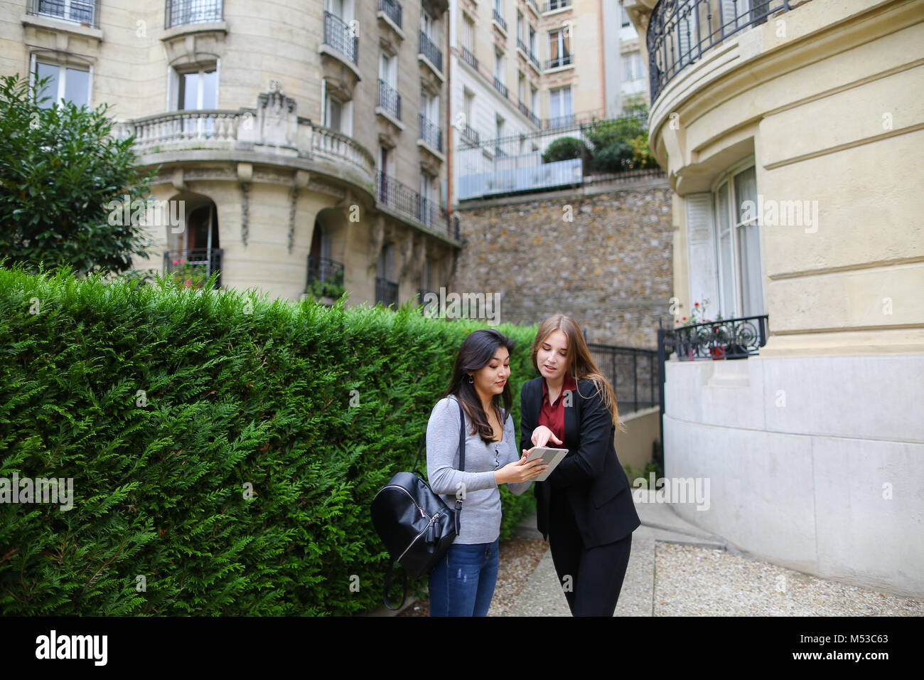 Jocund girl paying Chinese teacher with card and tablet for less Stock ...