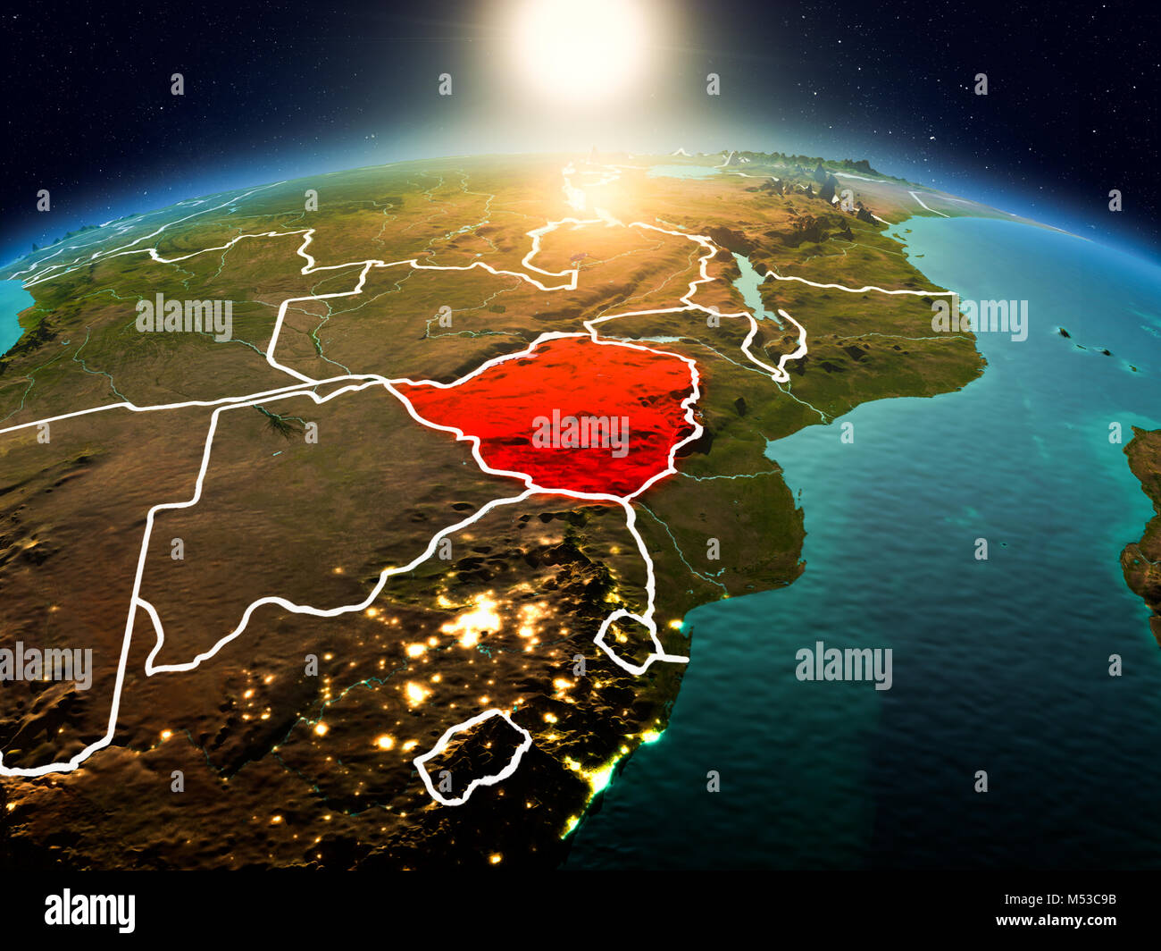 Sunrise above Zimbabwe highlighted in red on model of planet Earth in space with visible country ...