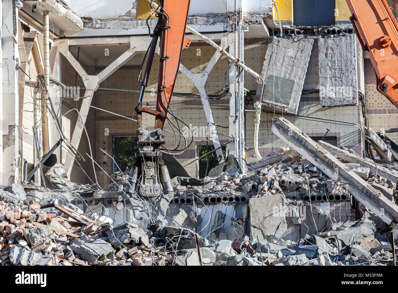 building demolition. excavator removes pieces of metal and stone from ...