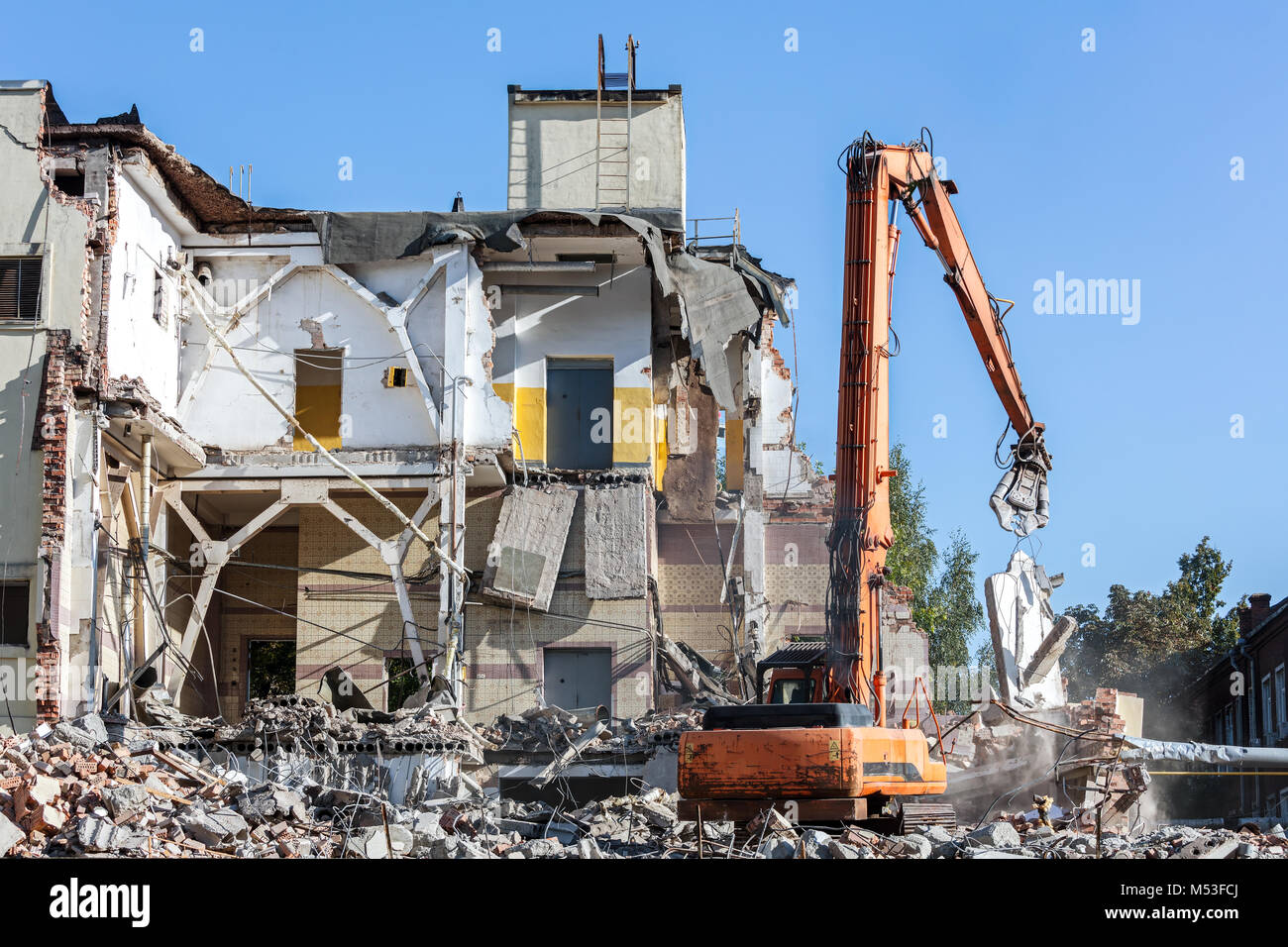 long arm of a demolition machine grab part of concrete wall Stock Photo ...