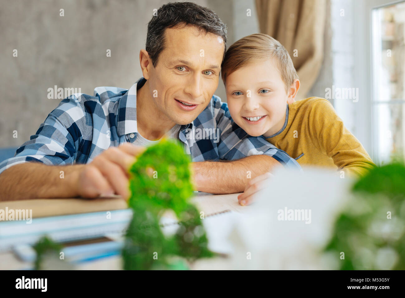 Happy father and son examining miniature city model Stock Photo - Alamy