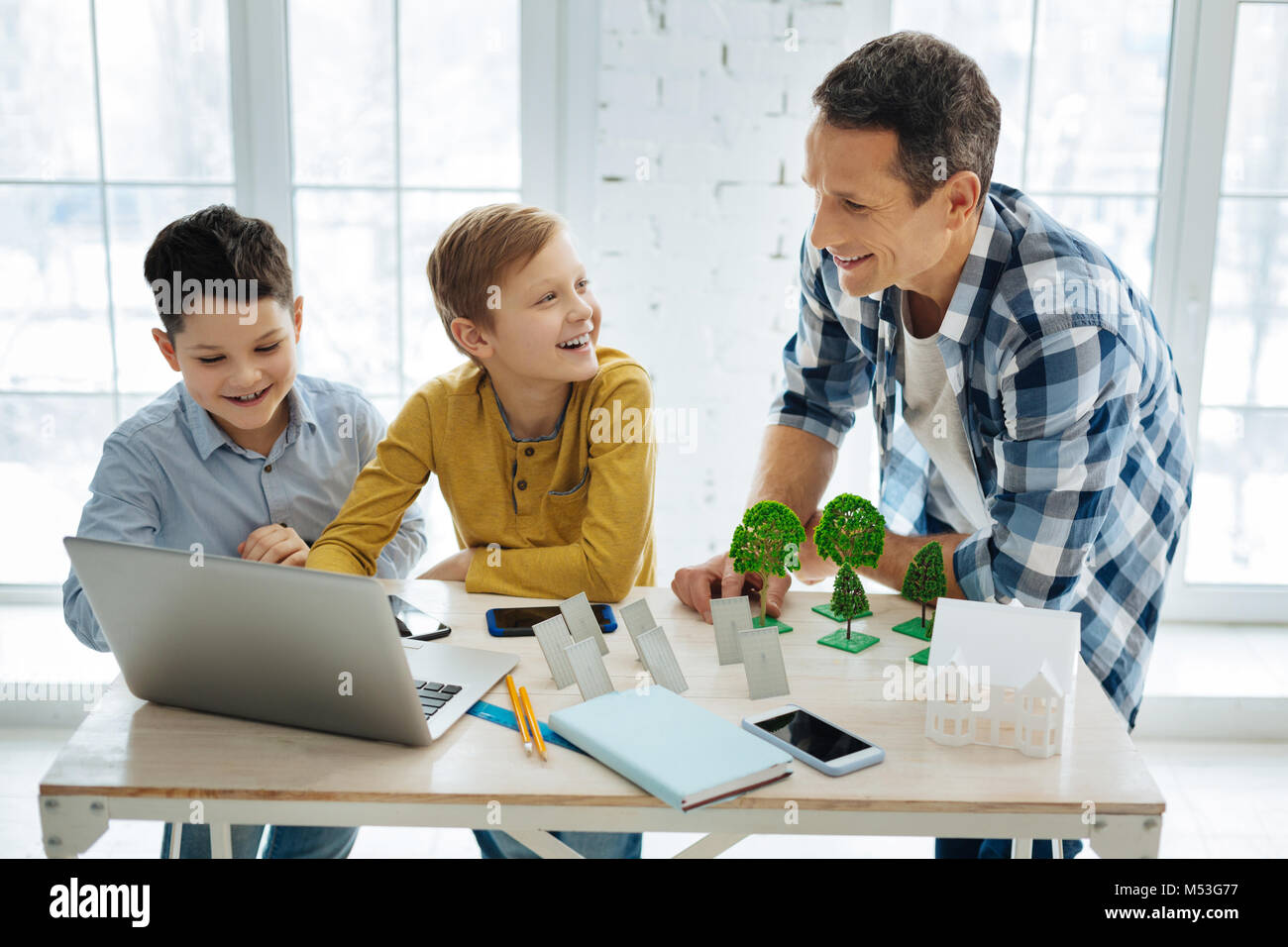 Cheerful boys watching their fathers project presentation Stock Photo ...