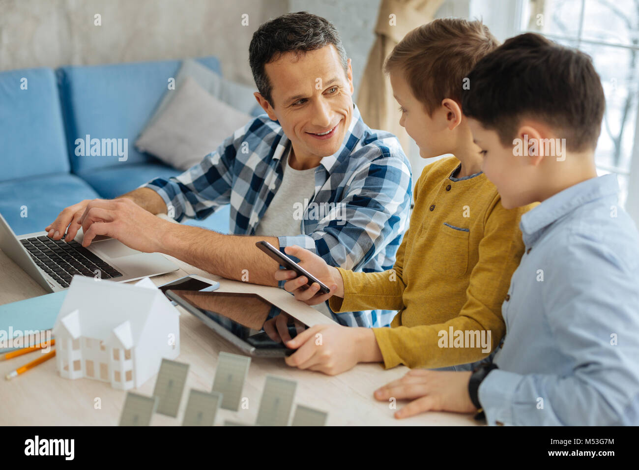 Cheerful kids asking questions about fathers devices Stock Photo - Alamy