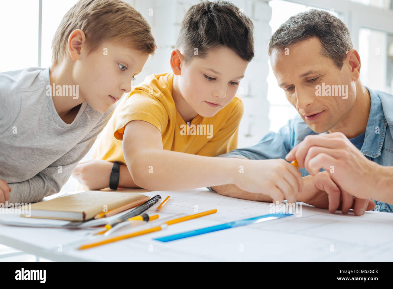 Pleasant father showing son how to use compass correctly Stock Photo ... Pleasant father showing son how to use compass correctly Stock Photo ...