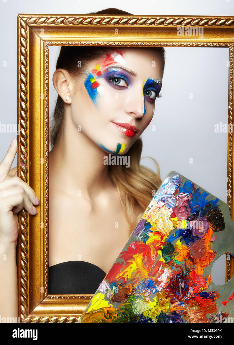 Young woman painter in golden frame with color palette in hand Stock ...
