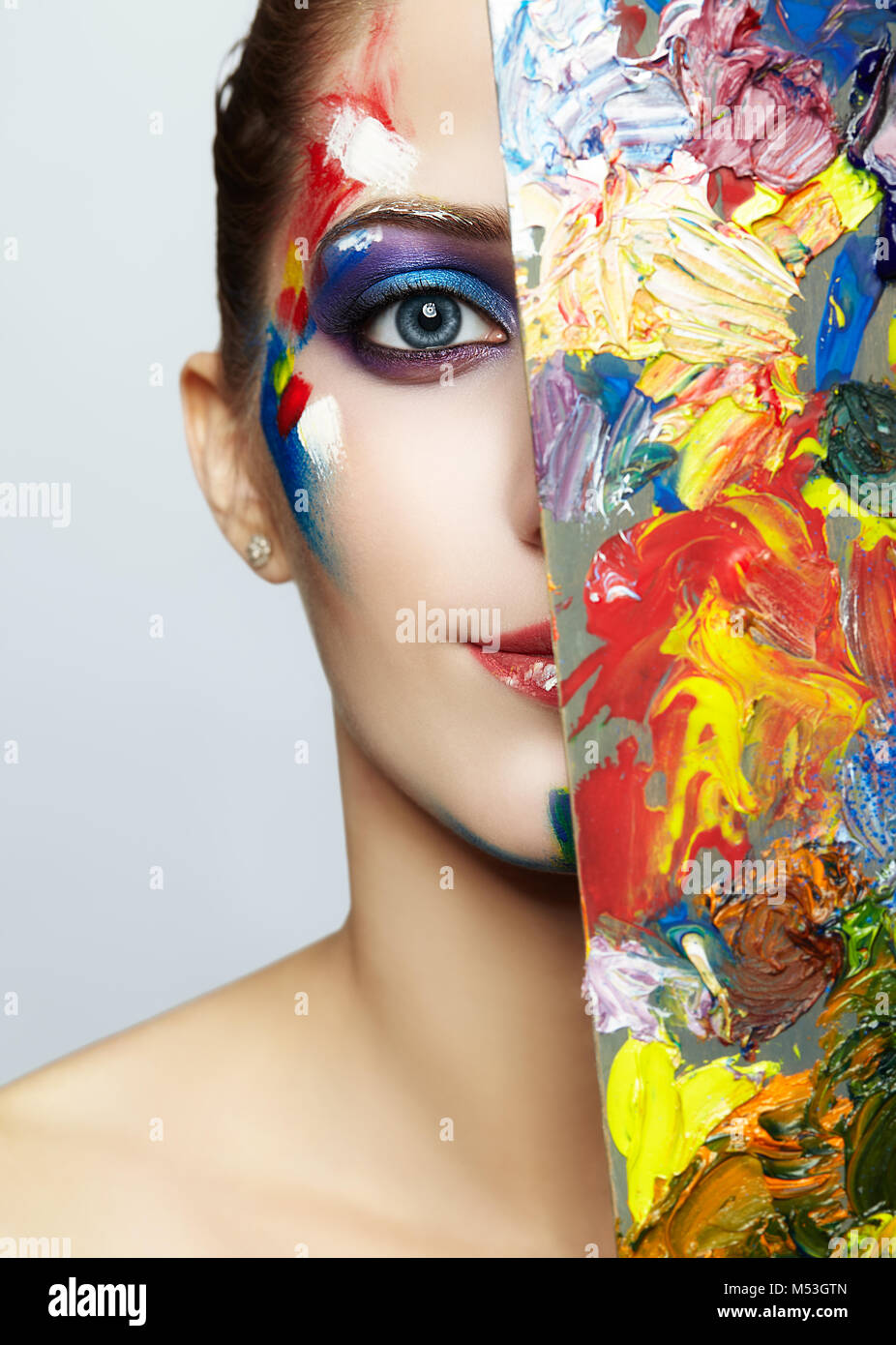 Young woman painter with color palette and acrylic paint on face Stock ...