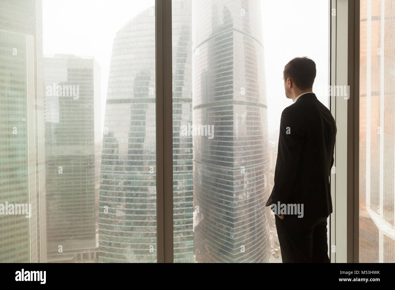 Company official looking through window in office Stock Photo - Alamy