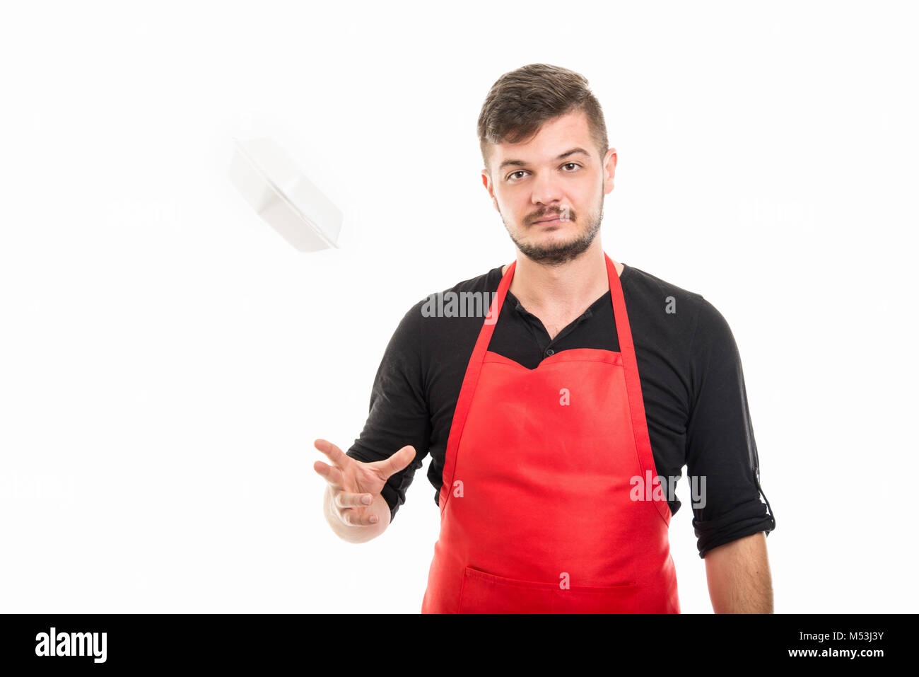 Male supermarket employer throwing up lunch box looking at camera ...