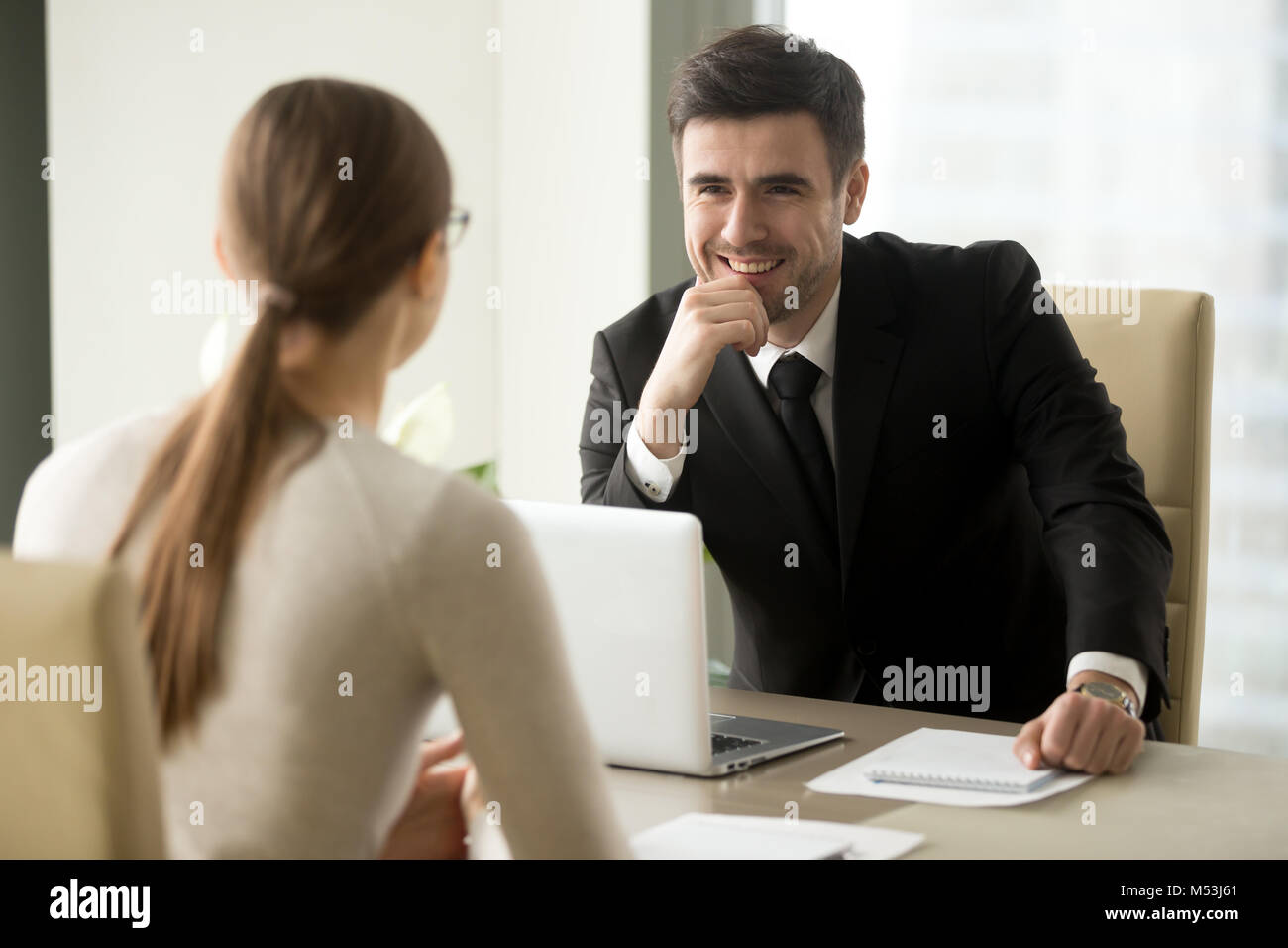 Smiling bank employee talking with female client Stock Photo - Alamy
