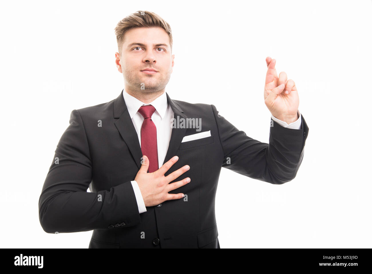 Handsome business man taking fingers crossed oath isolated on white ...