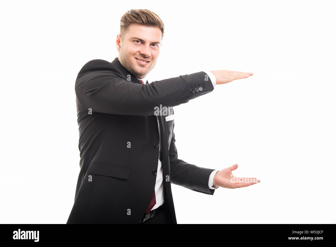 Handsome business man holding copyspace area and smiling isolated on ...