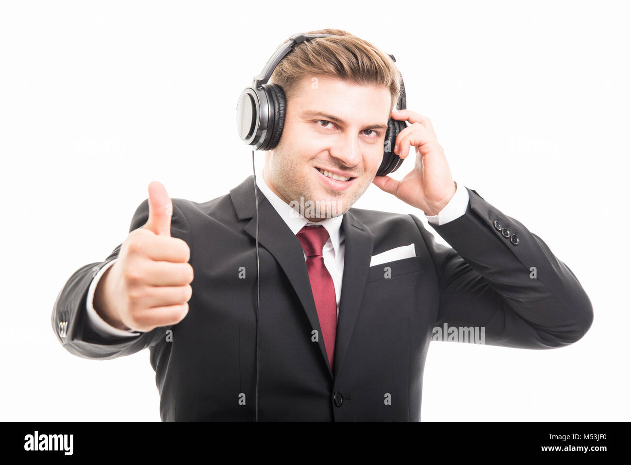 Young manager holding headphone showing like gesture isolated on white ...