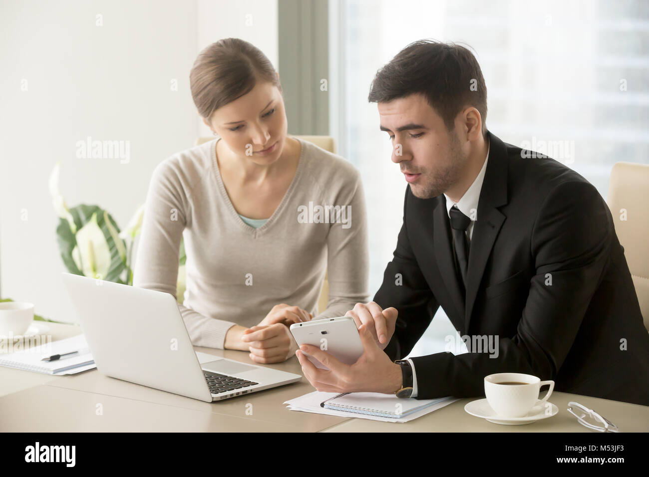 Male manager explaining tasks to female employee Stock Photo - Alamy