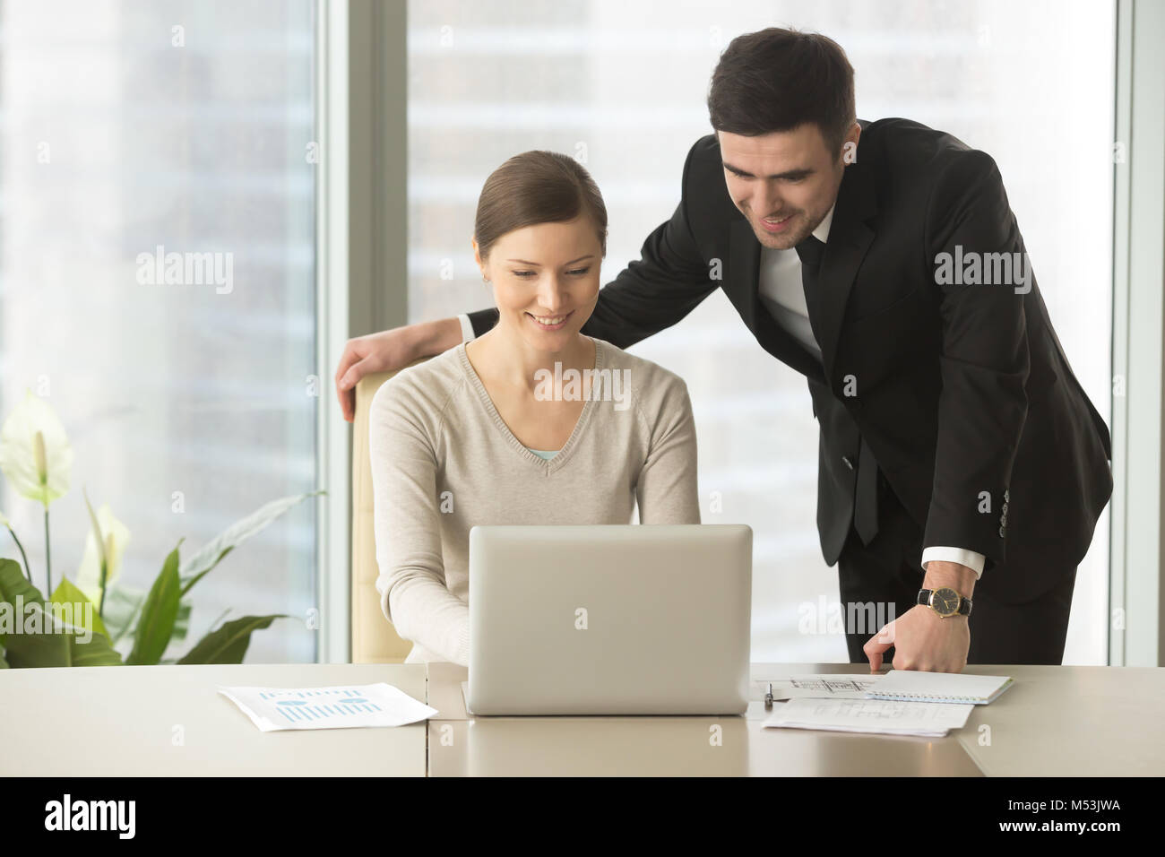 Happy company employees using laptop in office Stock Photo - Alamy