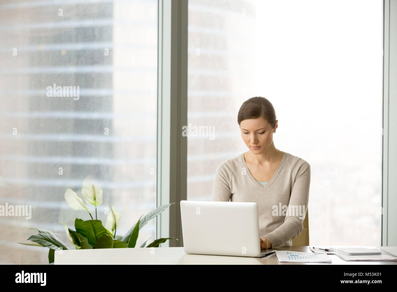 Female office worker using laptop on workplace Stock Photo - Alamy