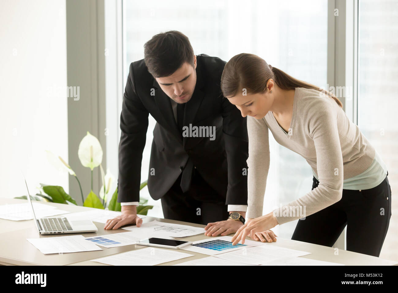 Female and male designers discussing colors scheme Stock Photo - Alamy