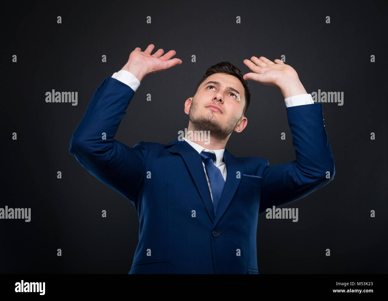 Executive manager pusing something invisible with hands on dark ...