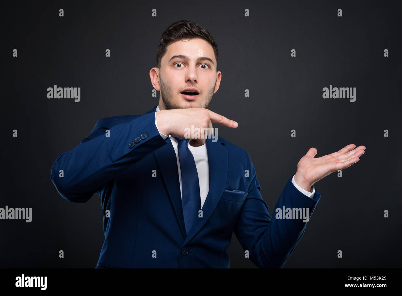 Friendly businessman showing and pointing to something on the palm of ...