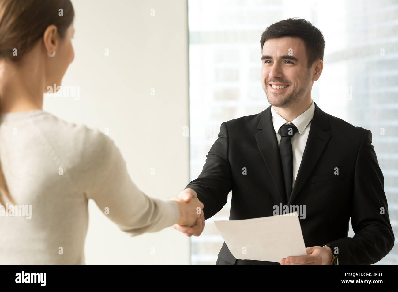 Boss congratulating female employee with promotion Stock Photo - Alamy