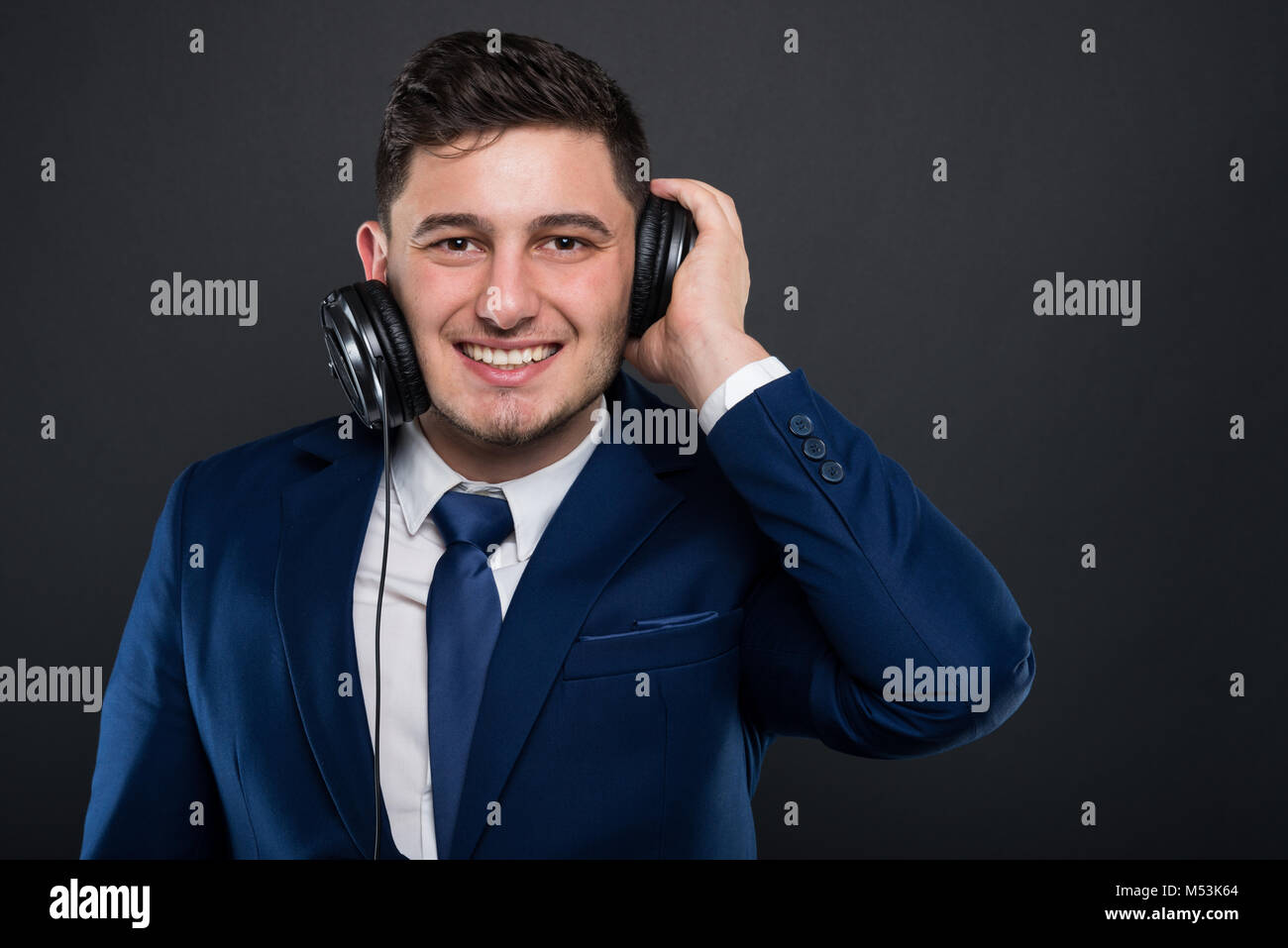 Cheerful ceo posing with modern headphones while listening music in his ...