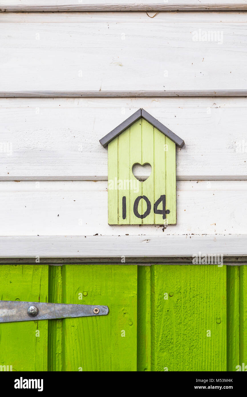 The number 104 on a white an green door Stock Photo - Alamy